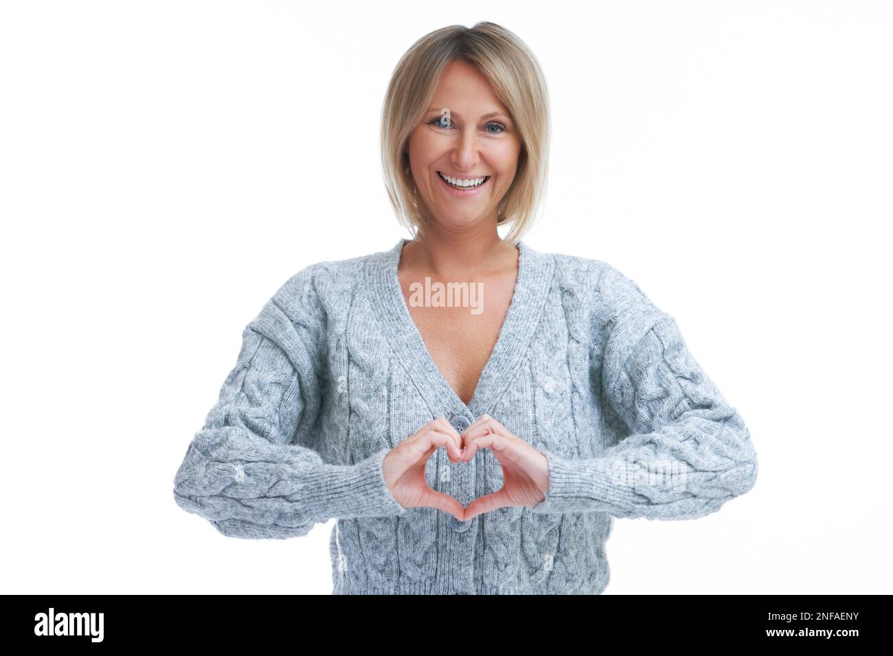 Picture of blonde woman over back isolated background showing heart ...