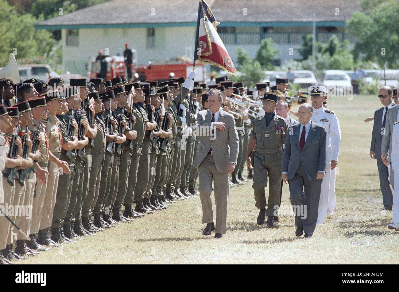 U.S. President George H. Bush tries on his sunglasses as he reviews ...