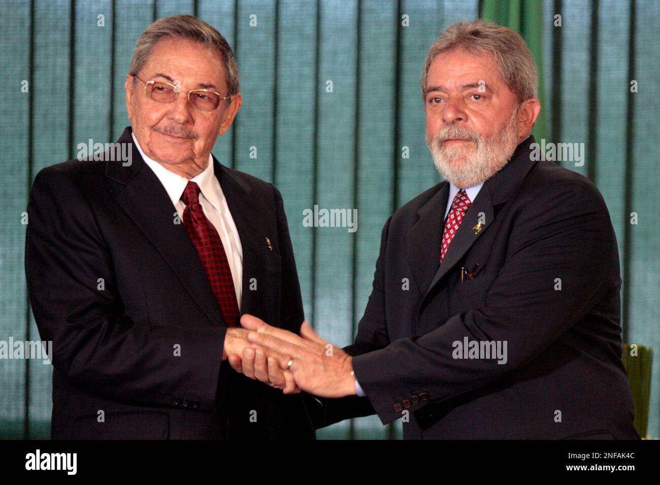 Cuba's President Raul Castro, left, shakes hands with Brazil's ...
