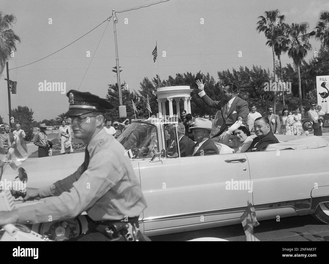 Cuban President Fulgencio Batista and his wife Marta wave to crowd along street during parade in ...