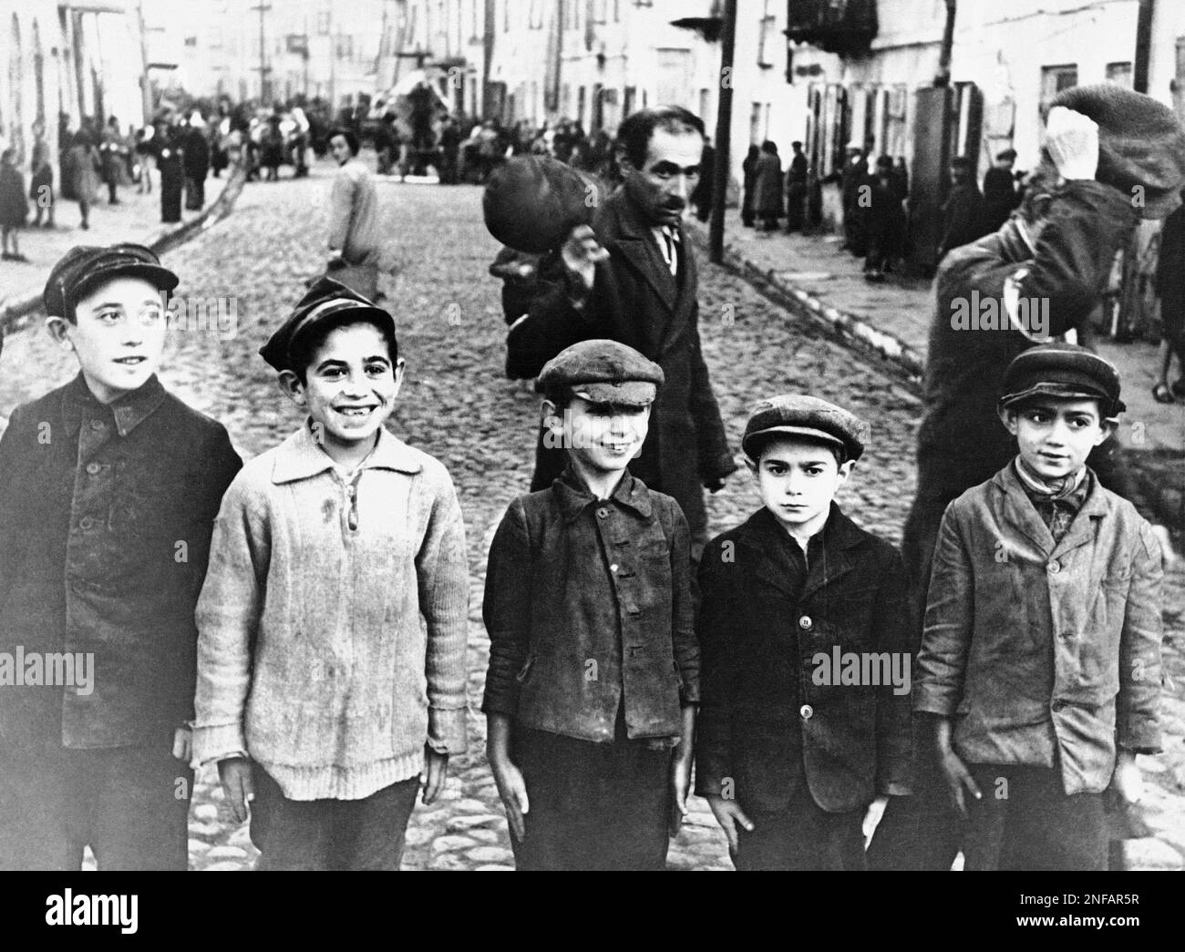 Men of the Lublin ghetto, behind boys, wear arm bands earmarking them ...