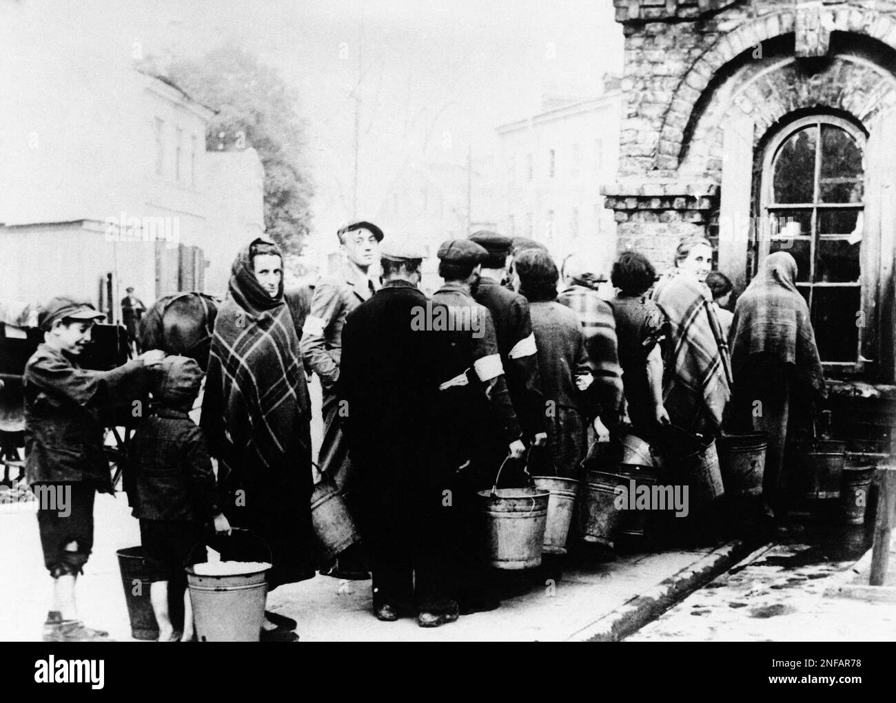 Jews line up in front of a well in the ghetto at Lublin, where they ...