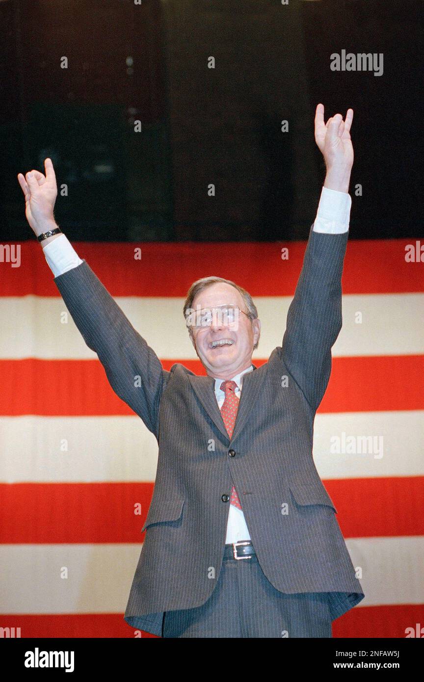 President-elect George Bush raises his arms and gives a "Texas Hook'em ...