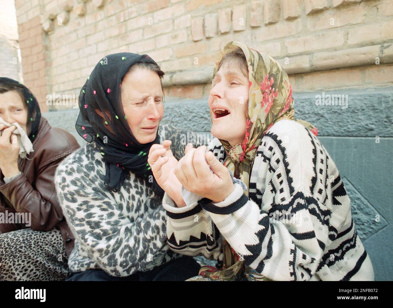 Two Chechen women grieve for their dead relatives in the village of ...