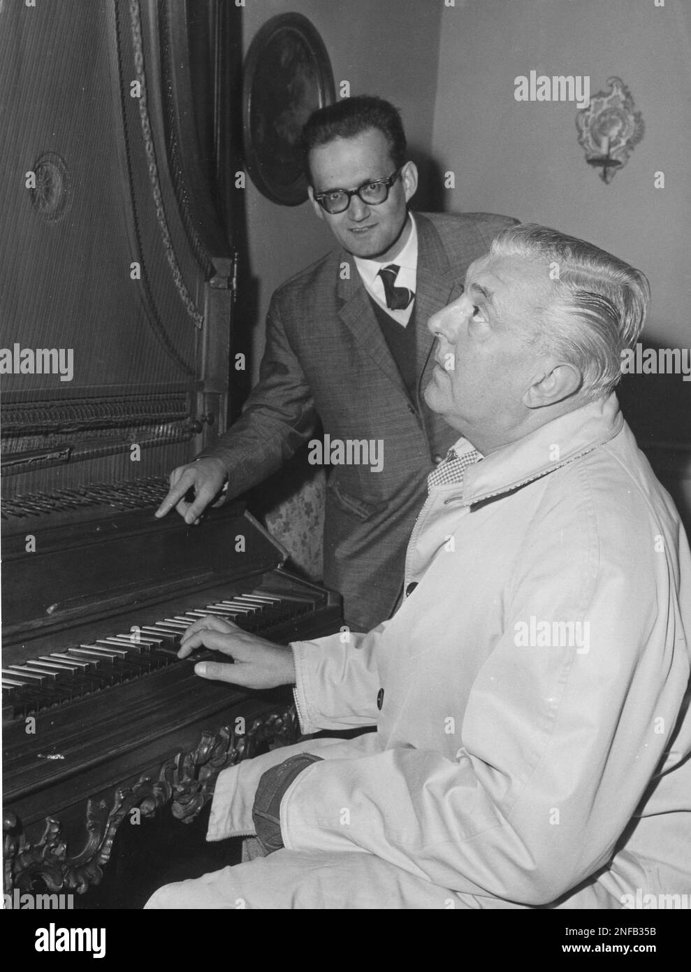 French actor and movie producer, Jacques Tati, right, tries the piano ...