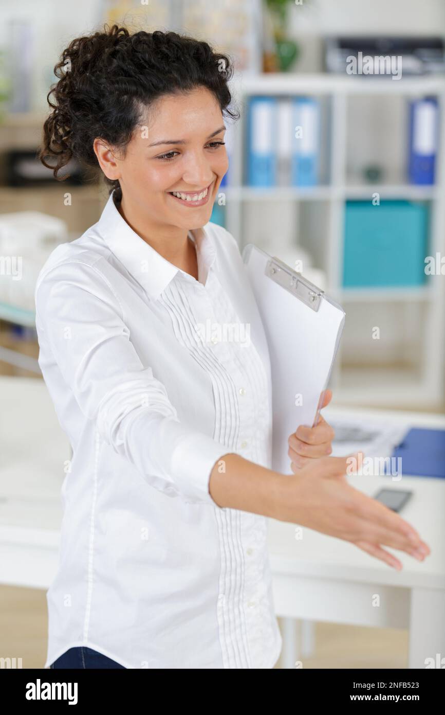 woman in an office greeting client with outstretched hand Stock Photo ...