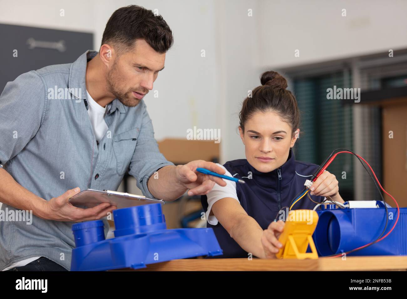 female apprentice repairing machine with teacher Stock Photo - Alamy