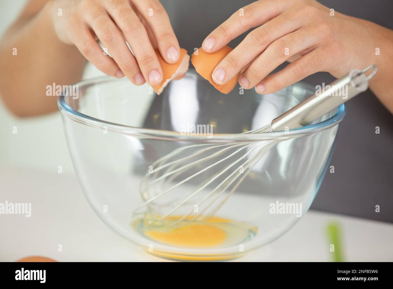 breaking an egg into a glass bowl Stock Photo - Alamy