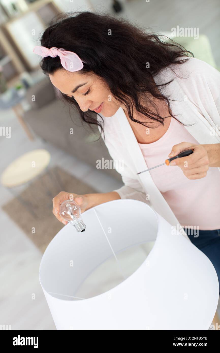woman changing light bulb in lamp at home Stock Photo - Alamy