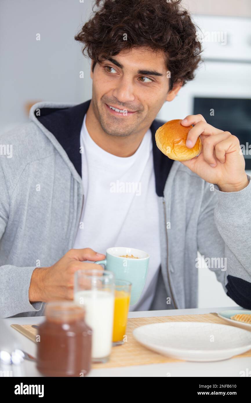 handsome man smiling eating breakfast Stock Photo - Alamy