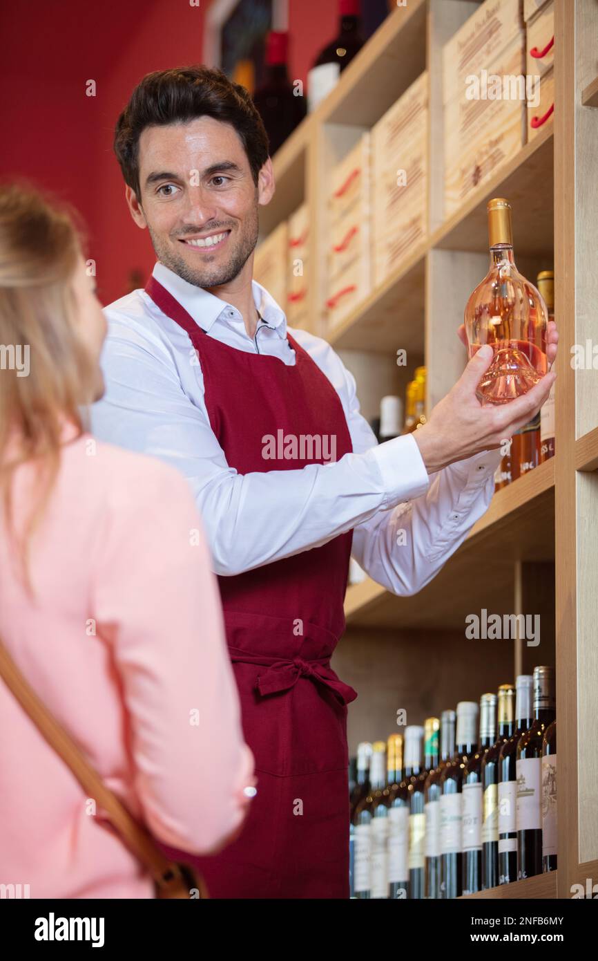 Salesman in supermarket offering bottle hi-res stock photography and ...