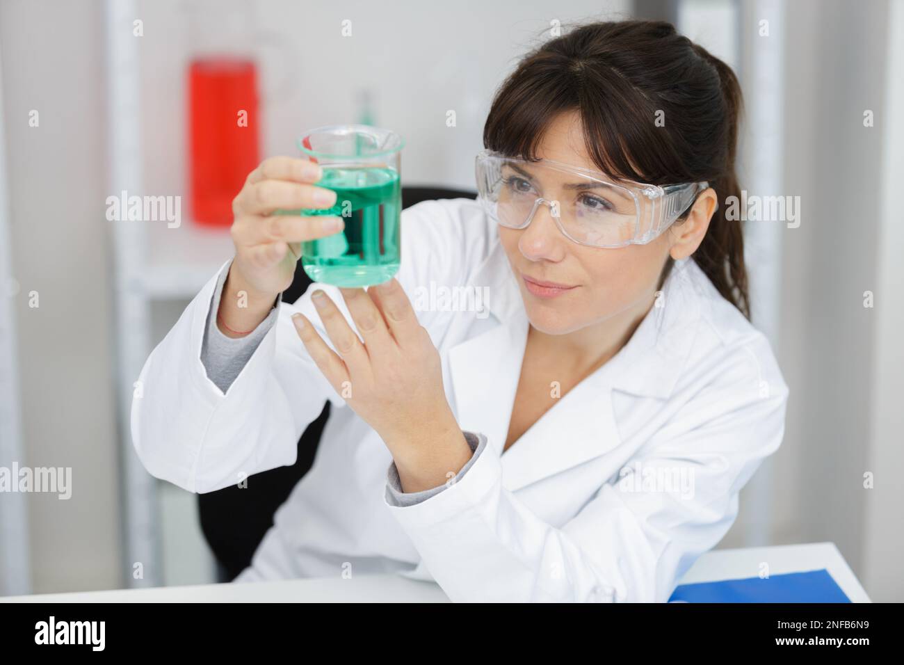 middle-aged female scientist looks at plastic tubes Stock Photo - Alamy