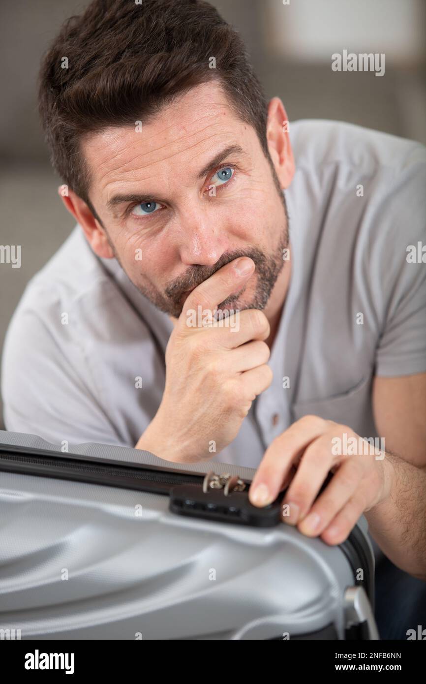 man trying to remember the code for his suitcase lock Stock Photo - Alamy