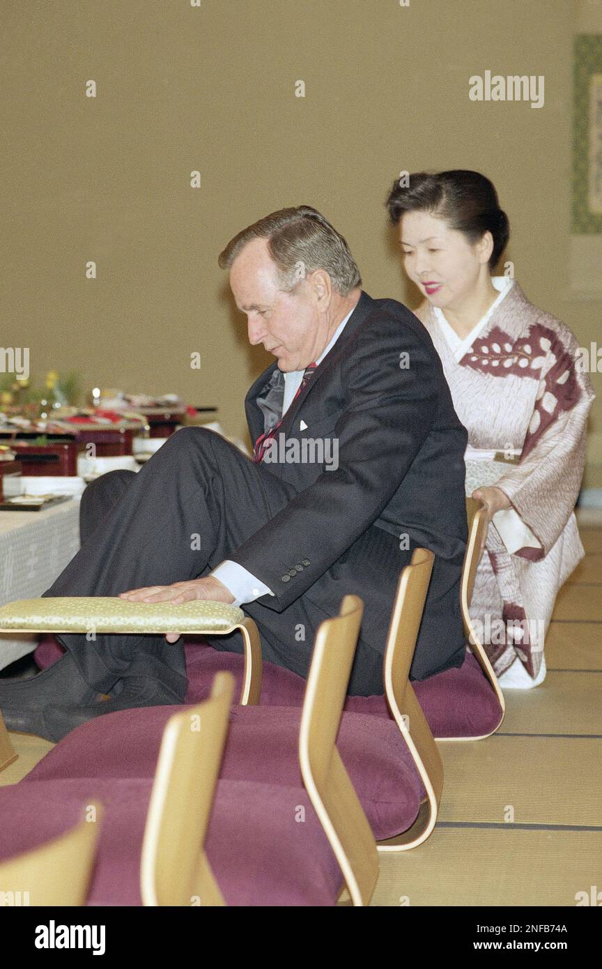 U.S. President George Bush squeezes in his legs to sit at a Japanese ...