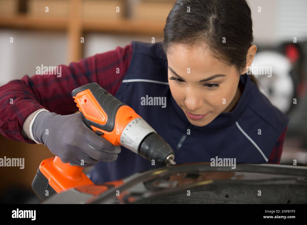 woman using electric screwdriver to repair car bodywork Stock Photo - Alamy