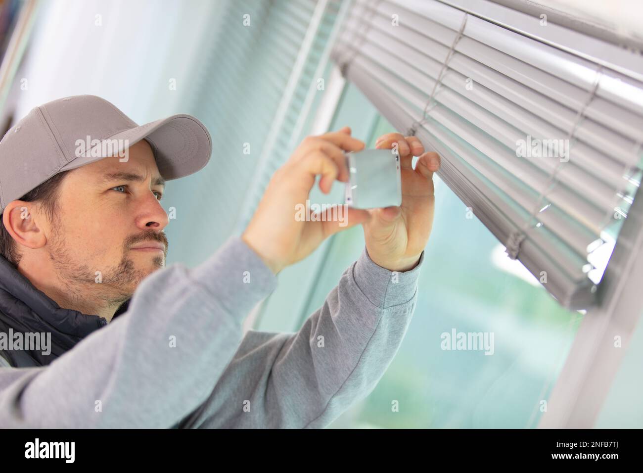 man installating roller shutter on window Stock Photo - Alamy