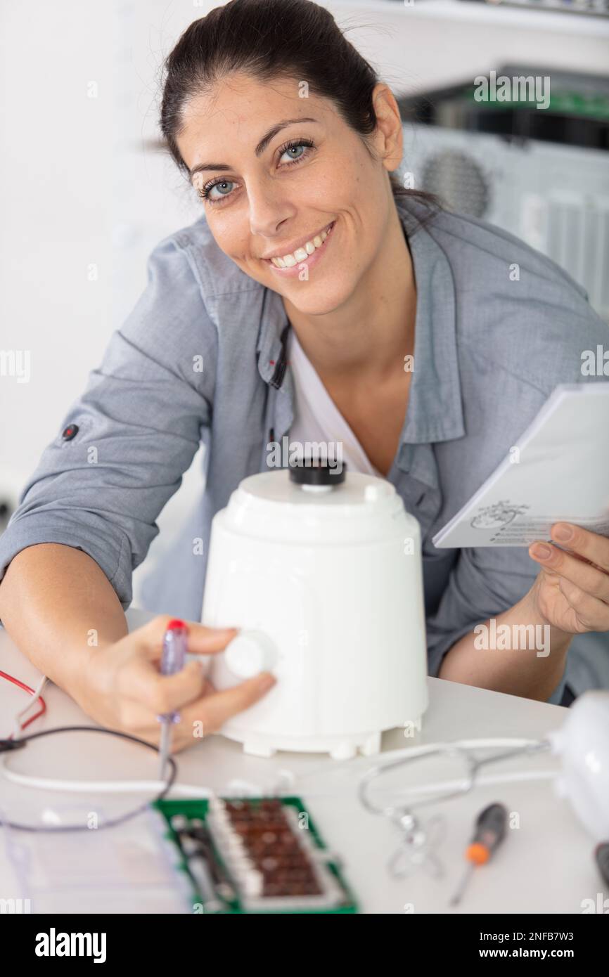 female technician assembling an appliance following instructions Stock ...