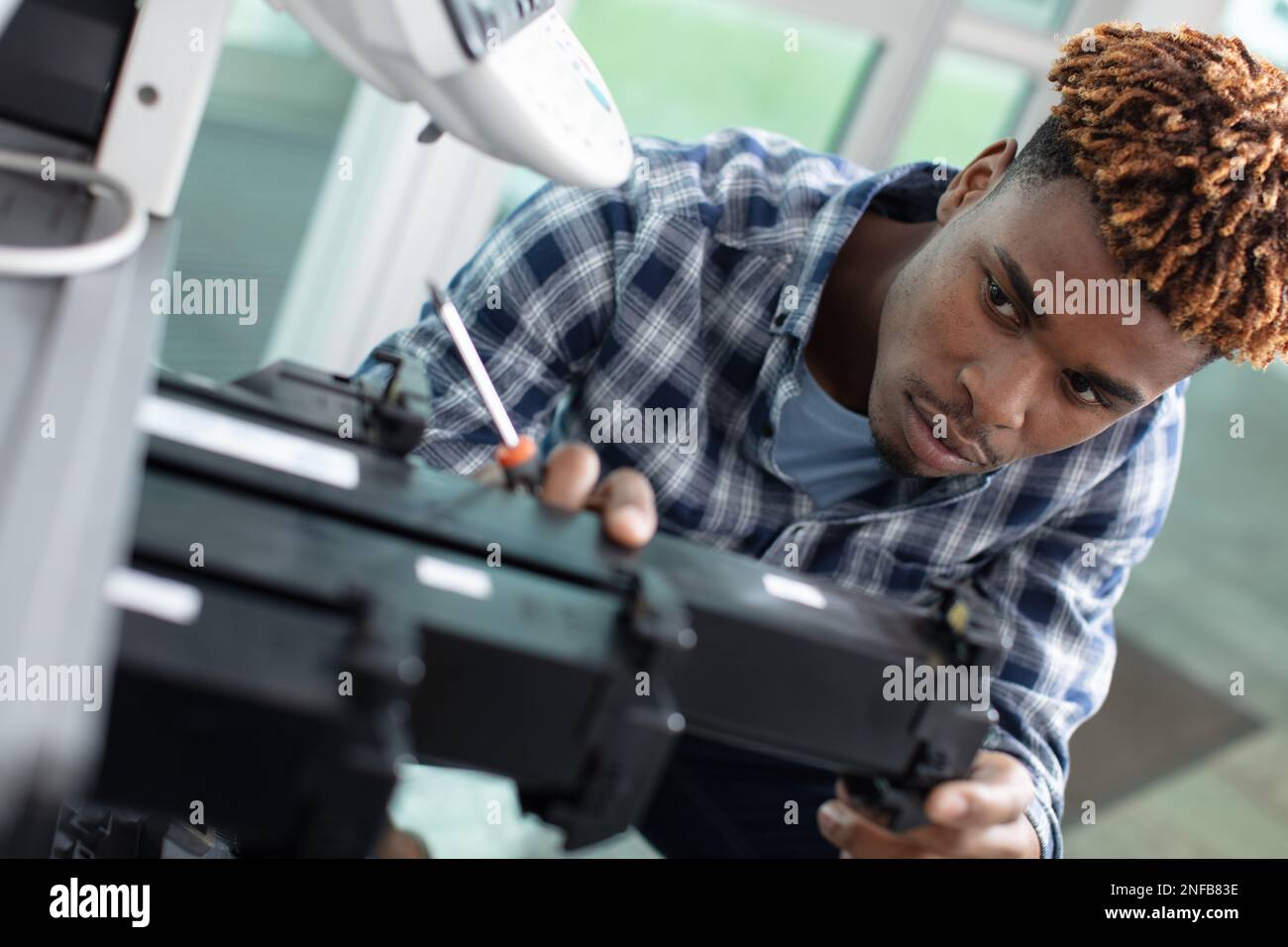 man technician trying to repair the office printer at work Stock Photo ...