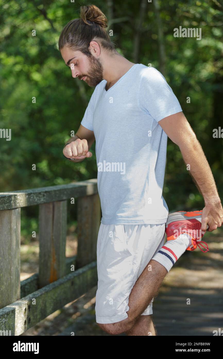 a male runner stretches legs Stock Photo - Alamy