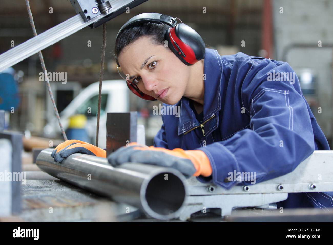 female handling pipe cut machinery in a metal workshop Stock Photo - Alamy