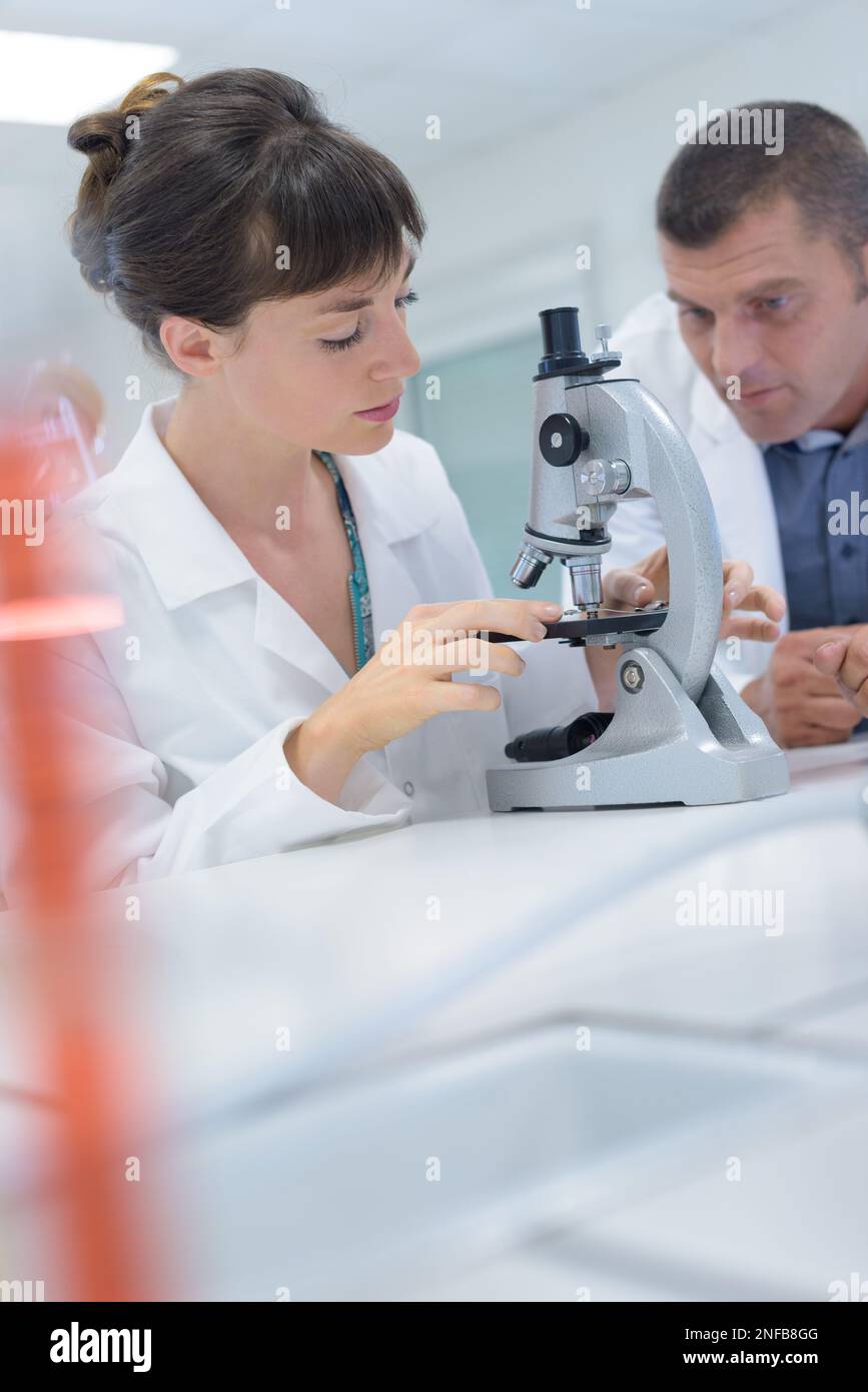 male and female scientists using microscope in laboratory Stock Photo ...