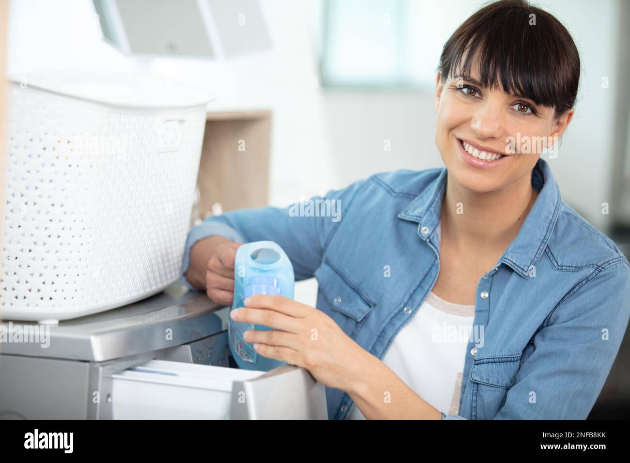 woman adding fabric softener to the washing machine Stock Photo - Alamy