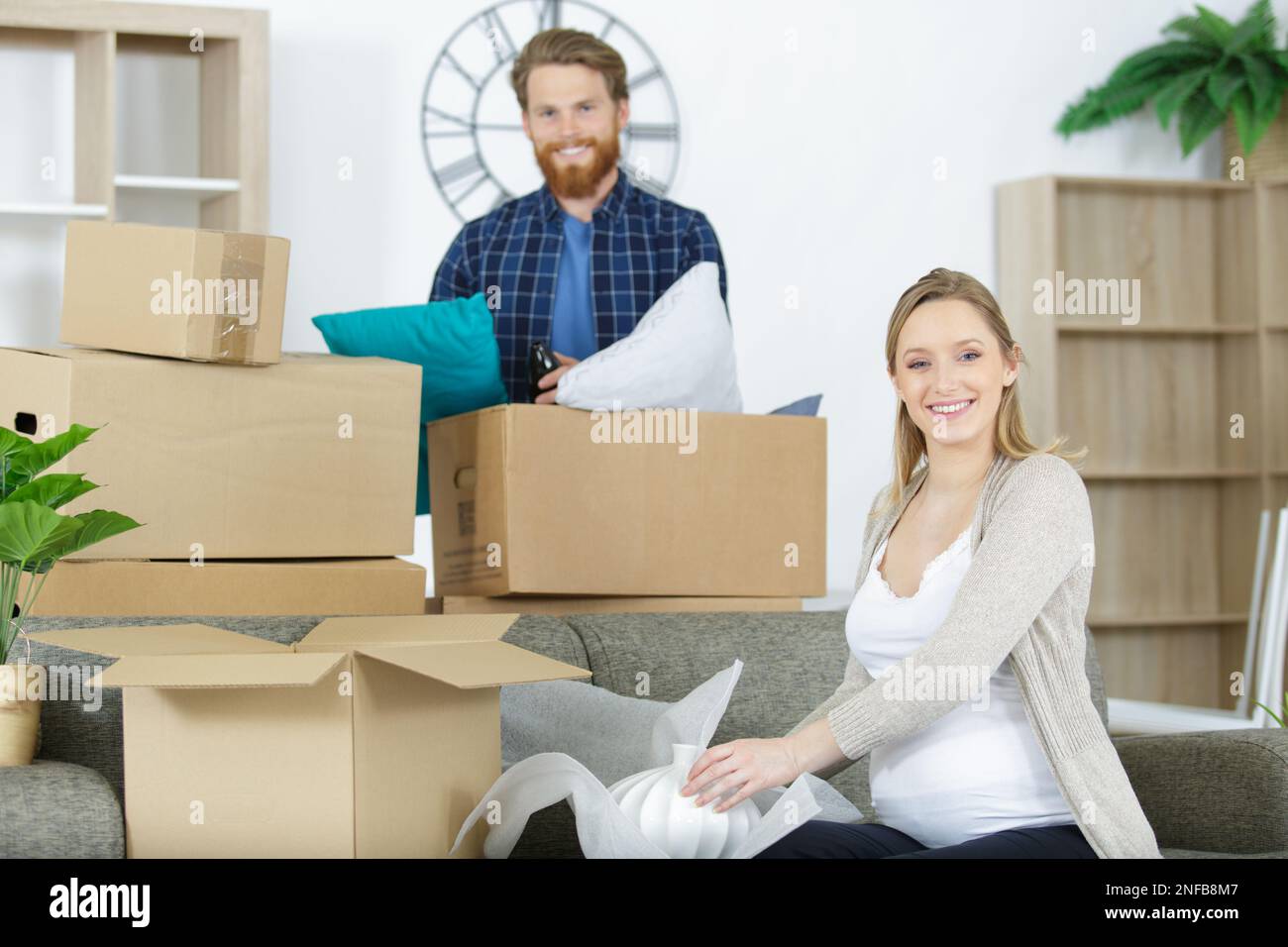 young pregnant couple packing cardboard boxes Stock Photo - Alamy