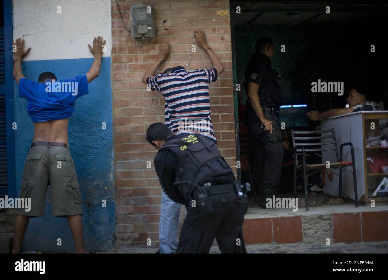 A man is frisked by a Baruta municipal police officer during a routine ...