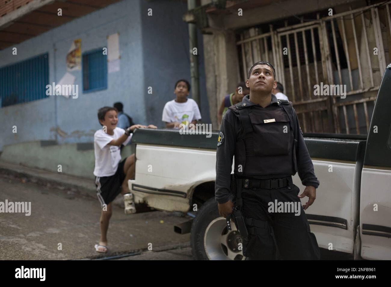 A Baruta municipal police officer looks up during a routine patrol ...