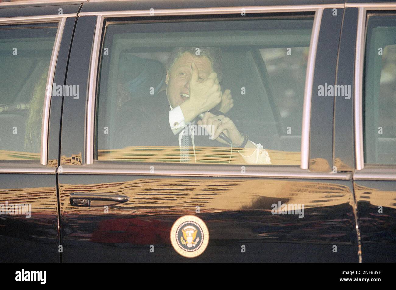 President Bill Clinton speaks in a microphone and gestures through the ...