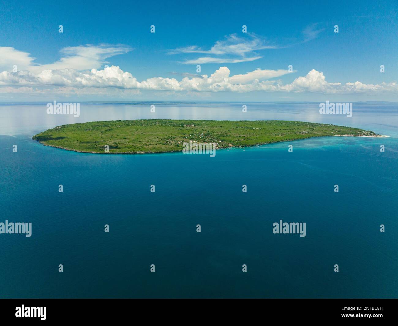 Tropical island against the blue sky and the ocean. Hilantagaan Island ...