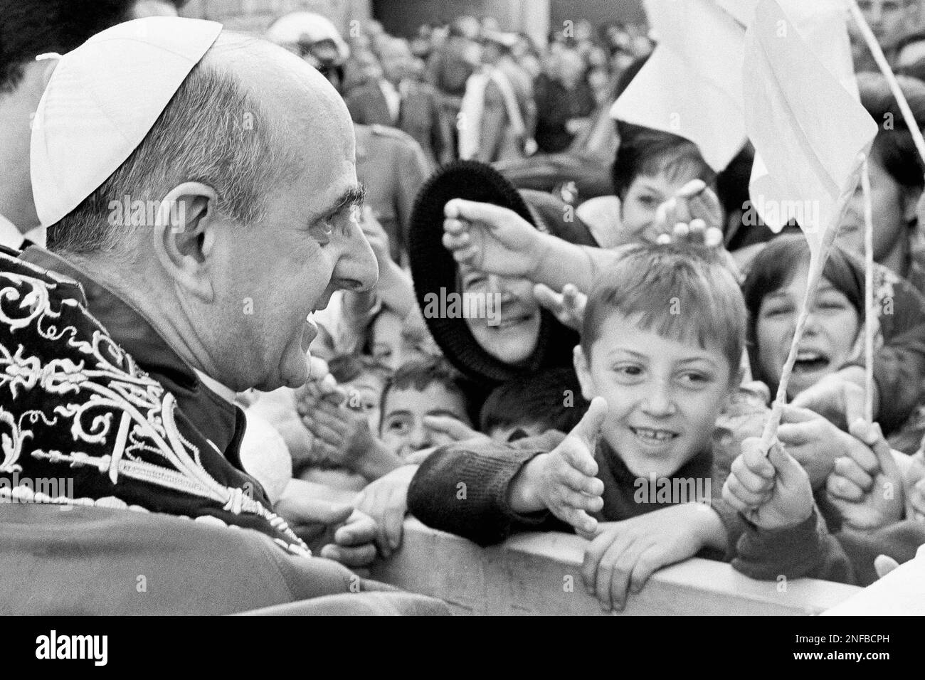 A smiling Pope Paul VI is greeted by children after he celebrated Mass ...