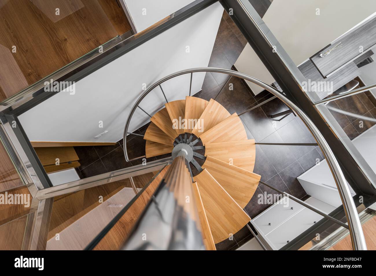Modern spiral staircase with wooden steps and metal railings looking ...