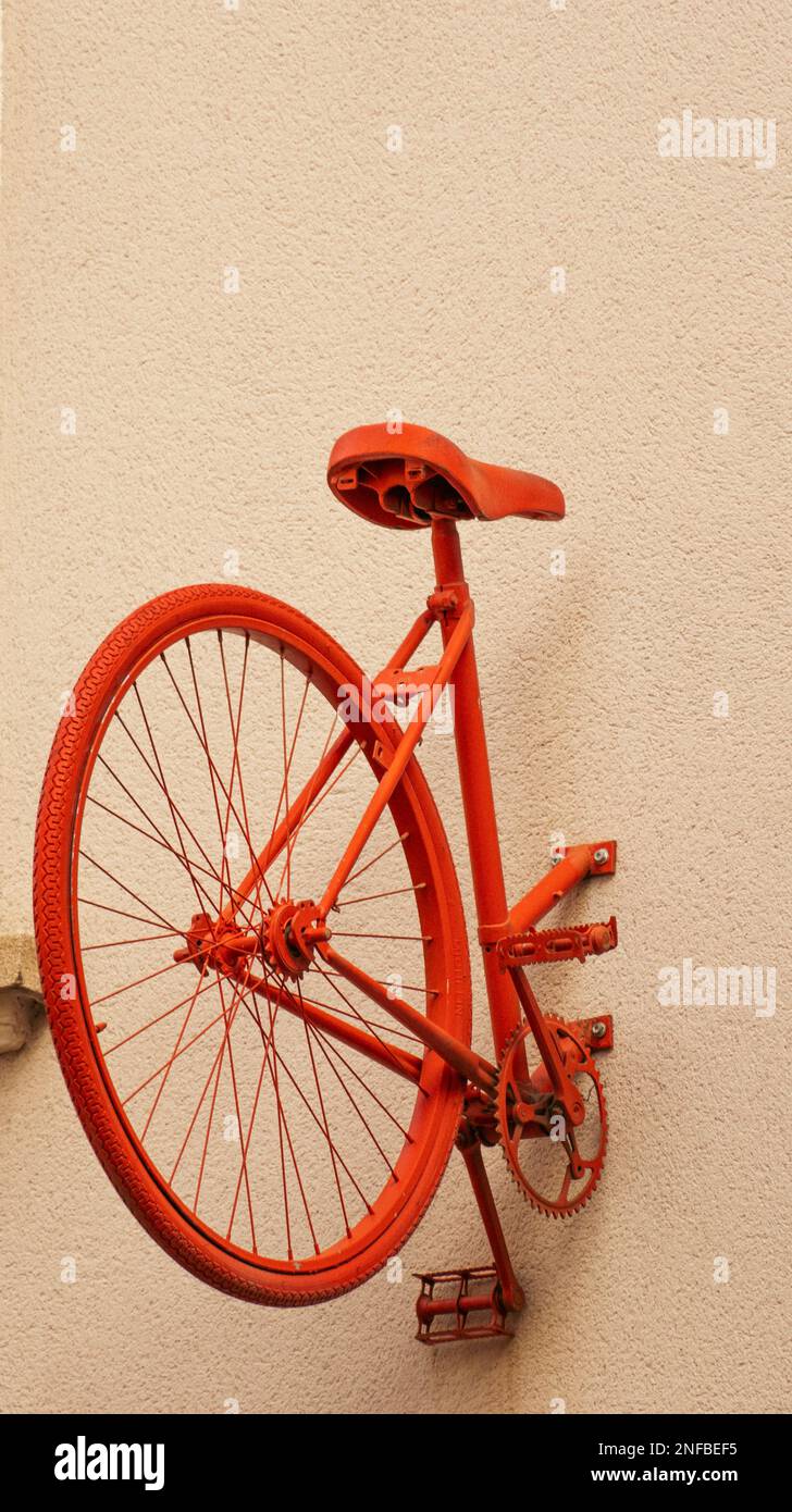 The rear half of a vintage red bicycle pinned to the wall of a ...