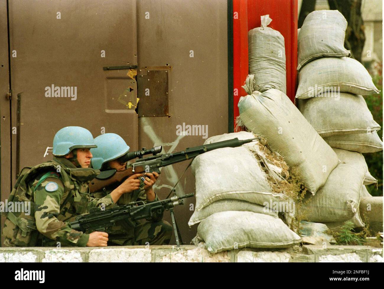 French United Nations soldiers take position behind sandbags and point ...