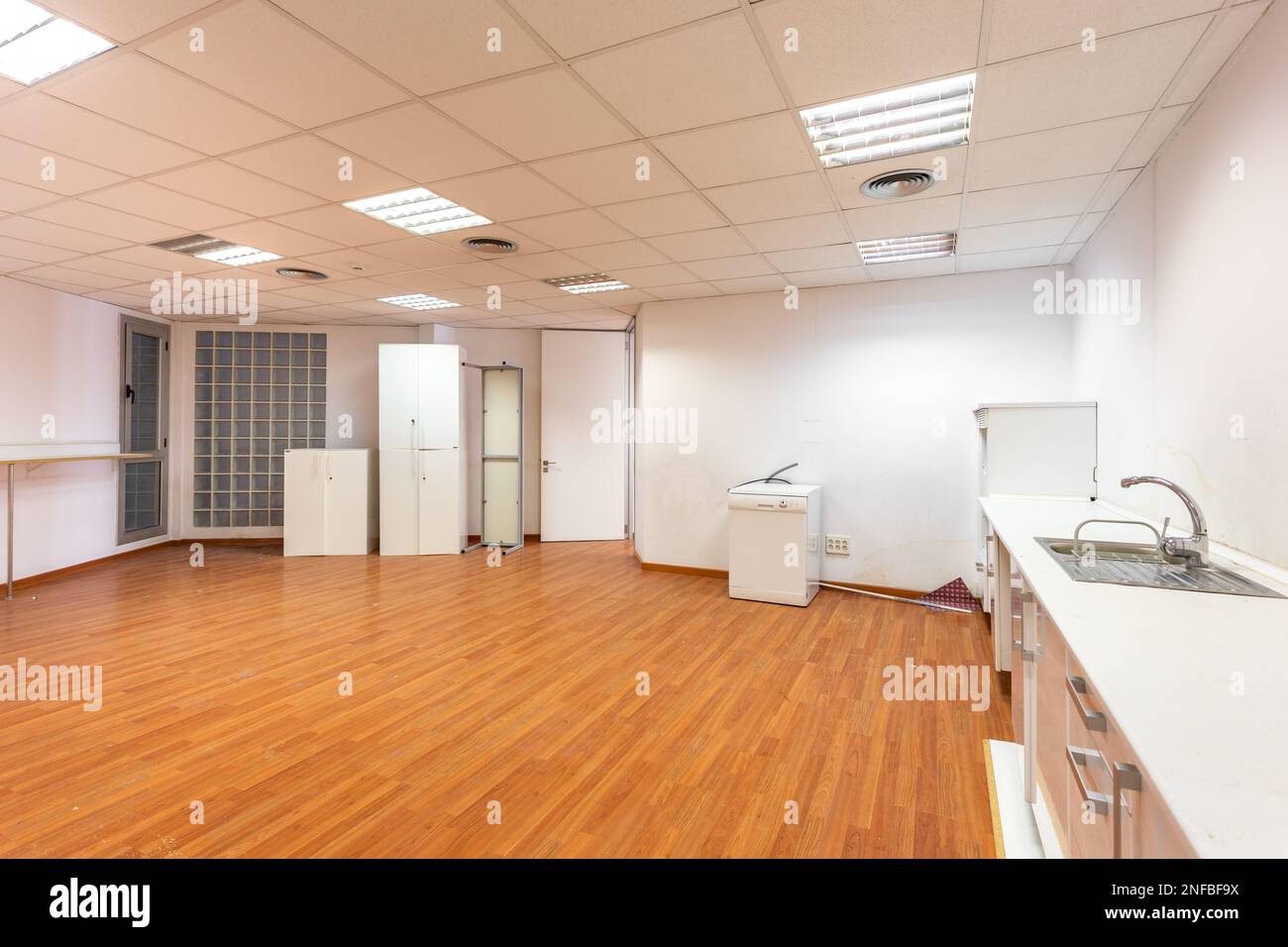 Old empty room with white kitchen furniture and sink that used to serve ...