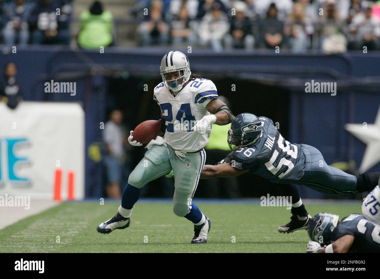 Dallas Cowboys running back Marion Barber, left, breaks a tackle from Seattle Seahawks ...