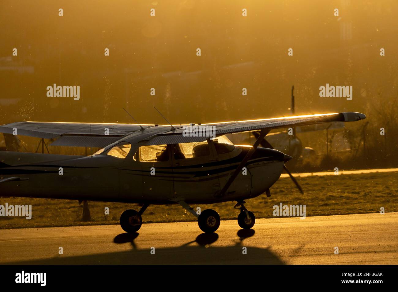 Silhouette of small propeller plane landing or taking off on the runway ...