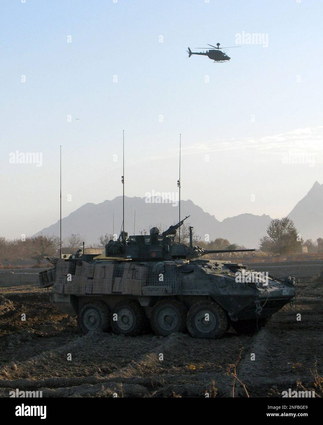 An American banshee heliicopter flies over a Canadian light armoured ...