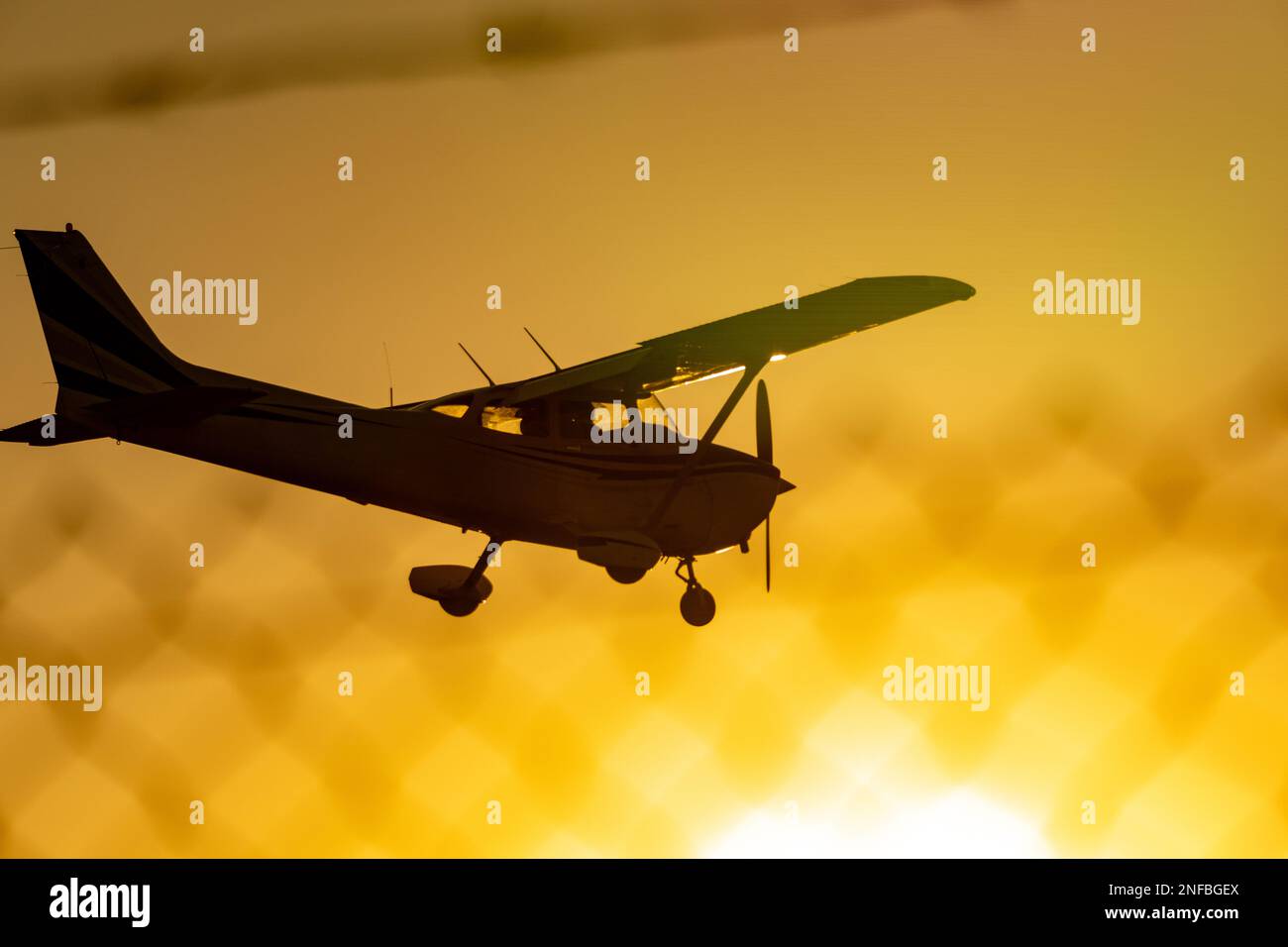 Silhouette of small propeller plane landing or taking off on the runway ...