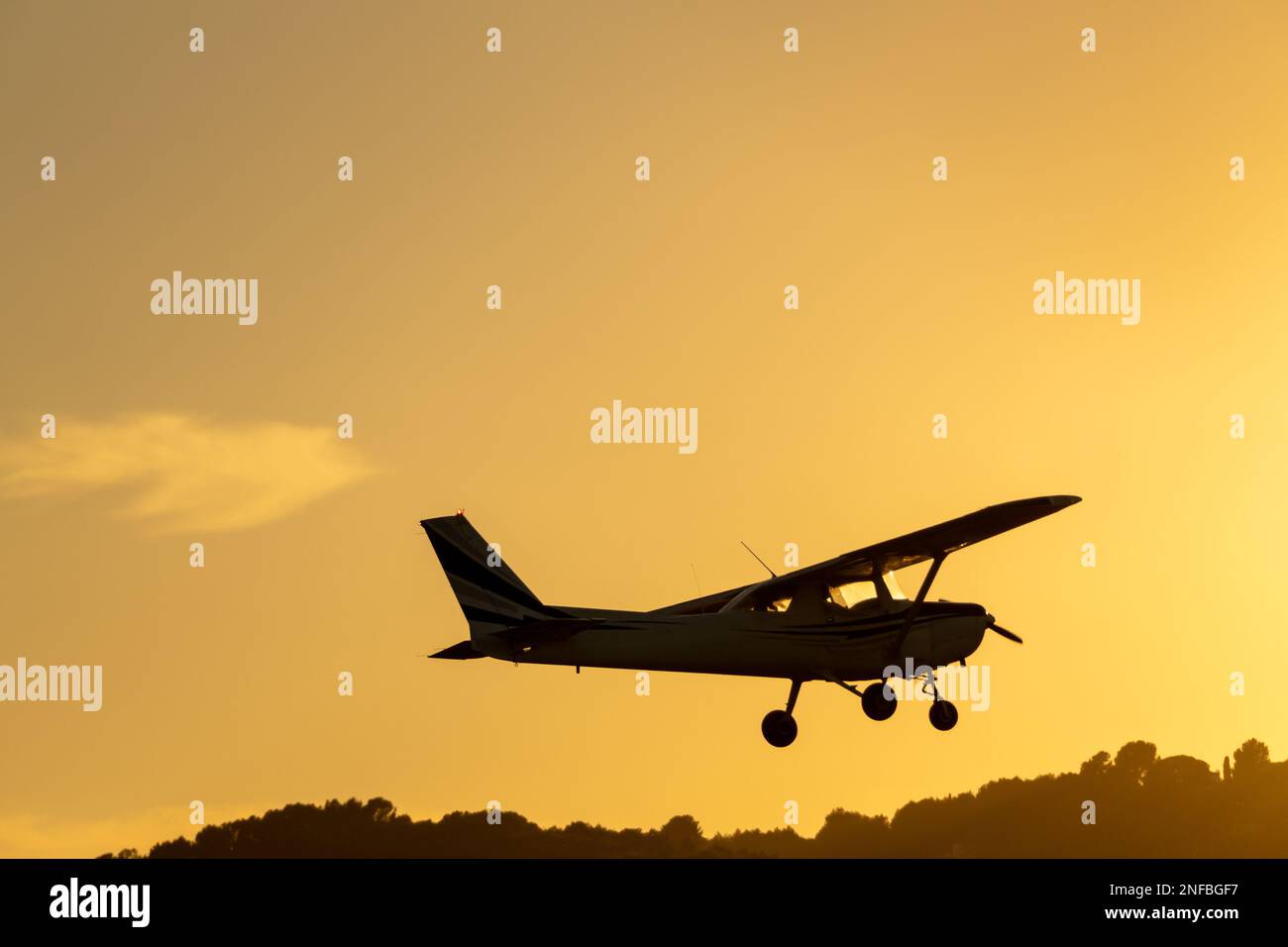 Silhouette of small propeller plane landing or taking off on the runway ...