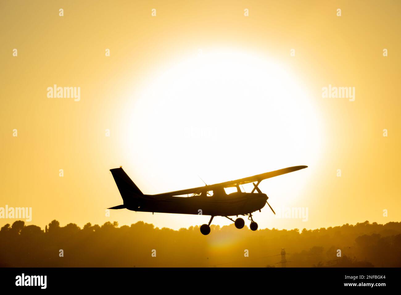 Silhouette of a small propeller plane landing or taking off on the ...
