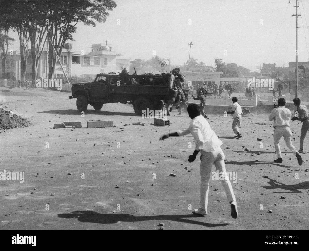 Police scramble into the back of a truck under fire from rocks thrown ...