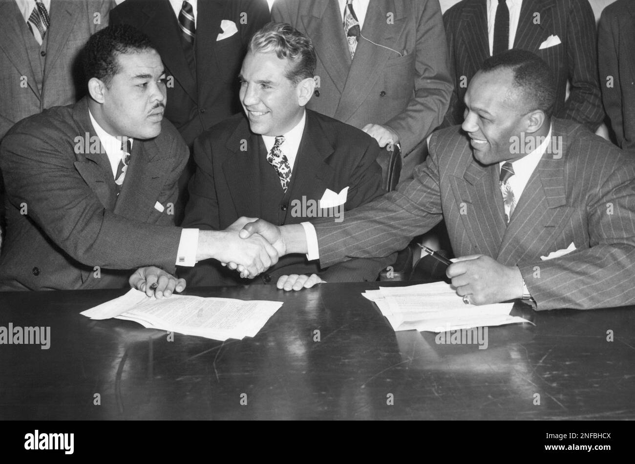 Joe Louis, left, world heavyweight boxing champion, shakes hands with a ...