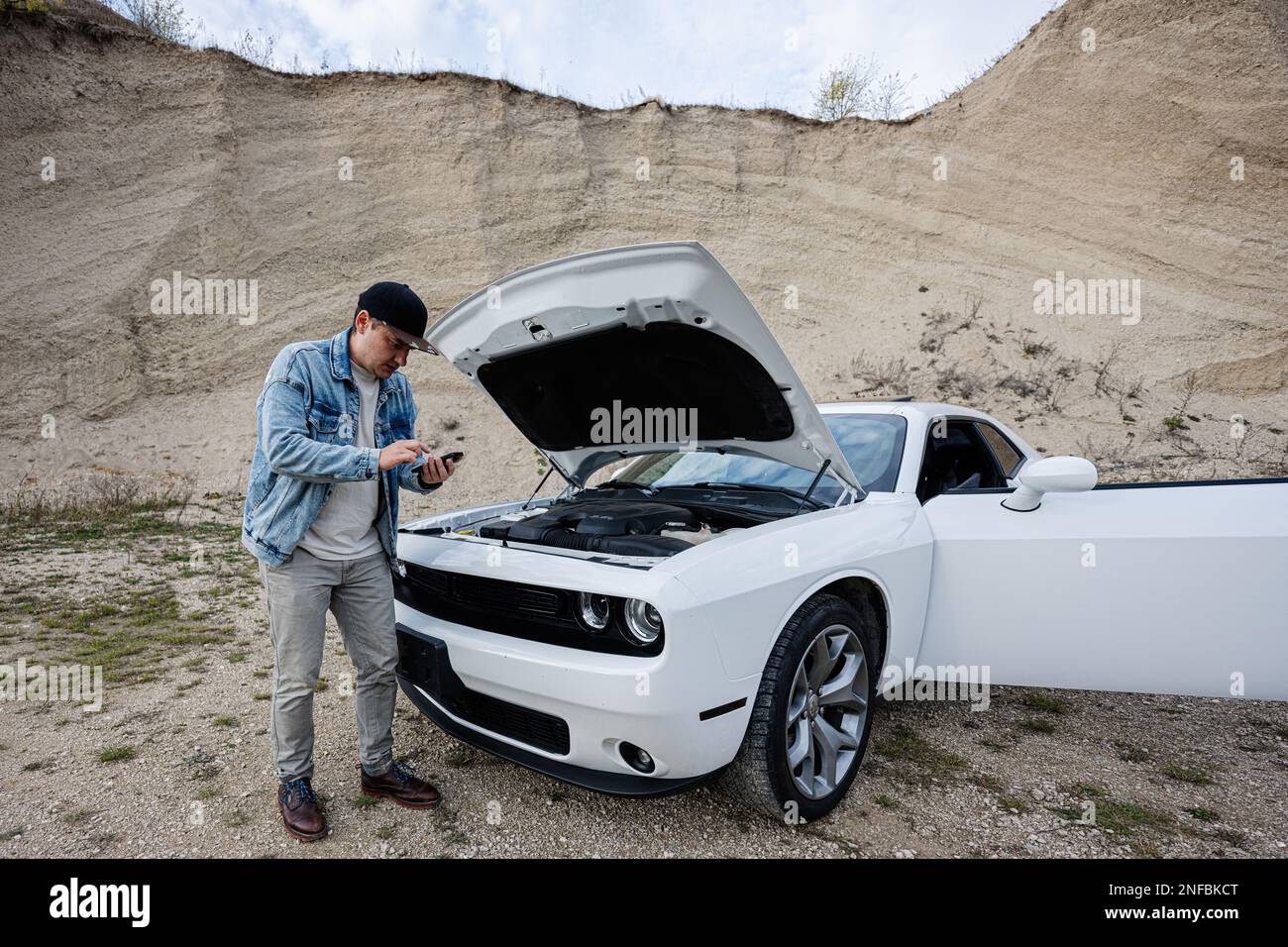 Shocked man is standing near his broken muscle car, open hood ... Shocked man is standing near his broken muscle car, open hood ...