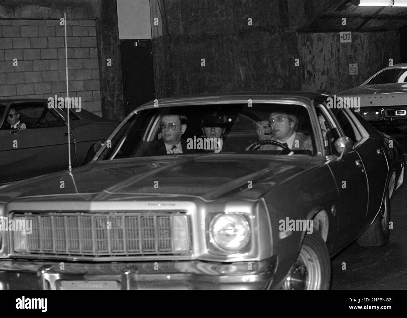 Angelo Buono, center, sits between officers in back of car leaving ...