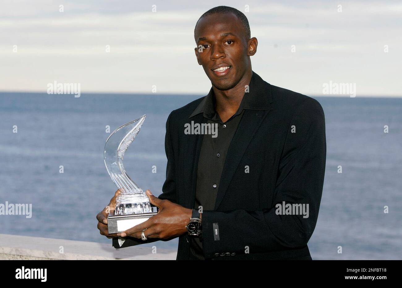 Jamaican sprinter, Usain Bolt holds his "Athlete of the Year Award ...