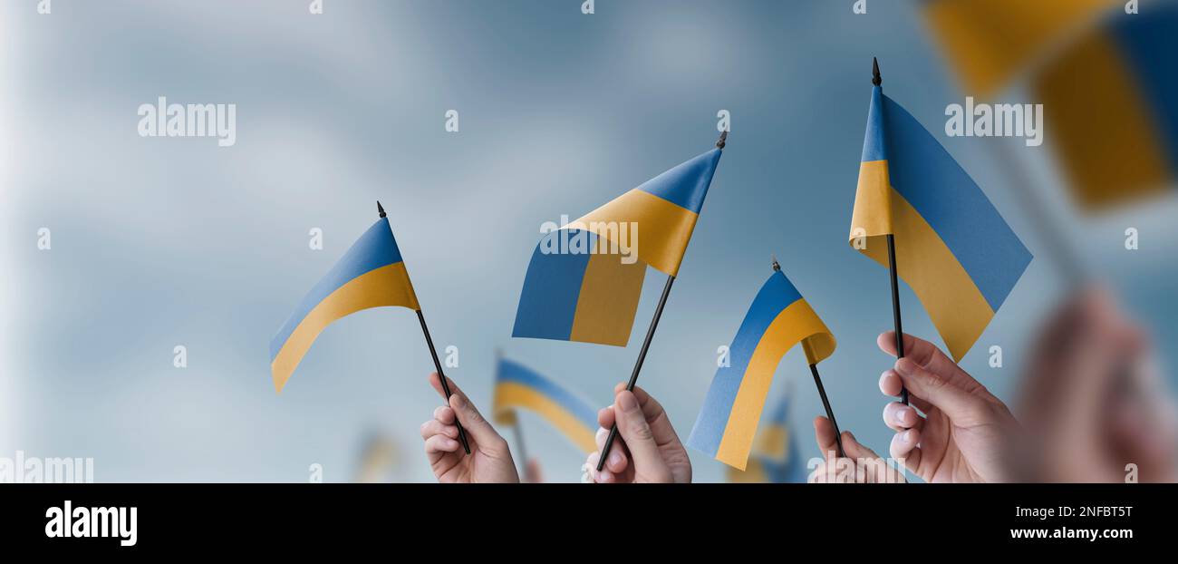A group of people holding small flags of the Ukraine in their hands ...