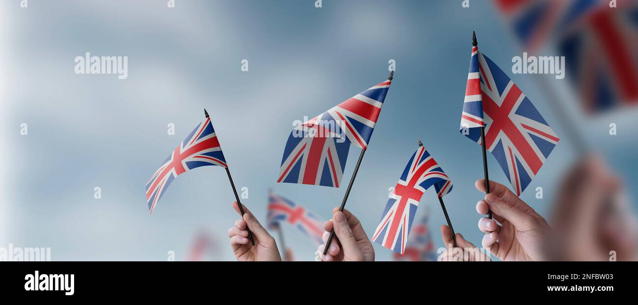 A group of people holding small flags of the United Kingdom in their ...