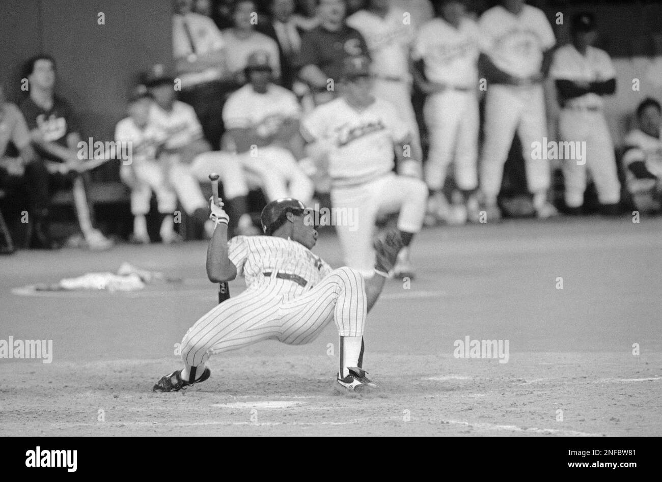 Rickey Henderson, bat for the American League, bends over backward ...